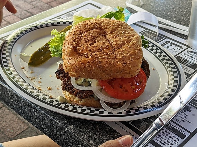 Behold the star of the show&mdash;a perfectly grilled burger on a sesame seed bun. That pickle on the side isn't just garnish, it's essential balance.