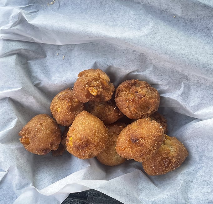 Golden-brown hush puppies that crunch like childhood memories. These little spheres of cornmeal joy are the perfect opening act to any seafood feast