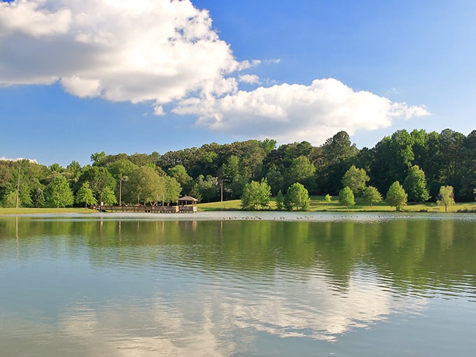 Nature's perfect mirror&mdash;Lamar Park's serene waters reflect both clouds and possibilities, offering a peaceful respite from Oxford's literary and culinary adventures.