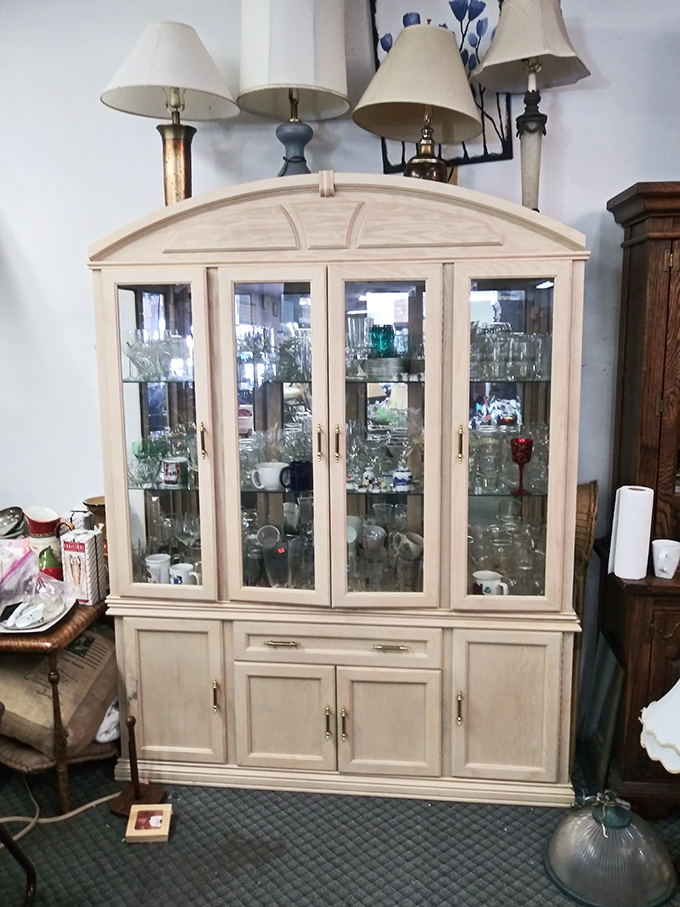 The cream-colored china cabinet stands like a dignified dowager, ready to showcase your grandmother's teacups or your quirky shot glass collection.