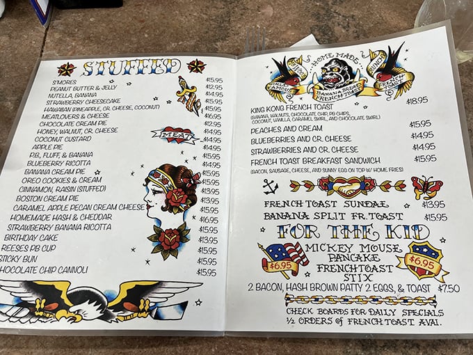 The menu reads like a love letter to breakfast indulgence, with artistic tattoo-style illustrations that make ordering "Sticky Buns" sound like a delicious act of rebellion.