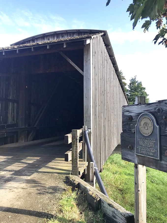 The bridge's entrance beckons with rustic charm. That historical marker isn't just decoration&mdash;it's bragging rights for surviving a century of Pacific Northwest weather.