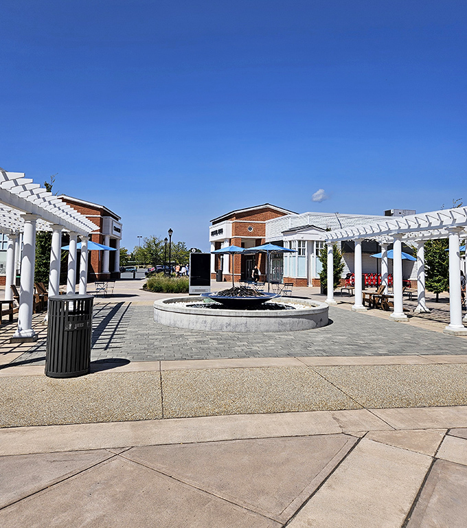 A serene courtyard oasis with white pergolas offers shoppers a moment to catch their breath between wallet-emptying adventures.