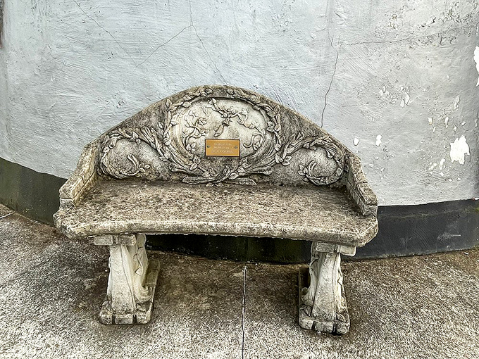 This ornate stone bench isn't just functional&mdash;it's a time capsule of craftsmanship, offering weary travelers a moment of rest against the Coffee Pot's curved wall.