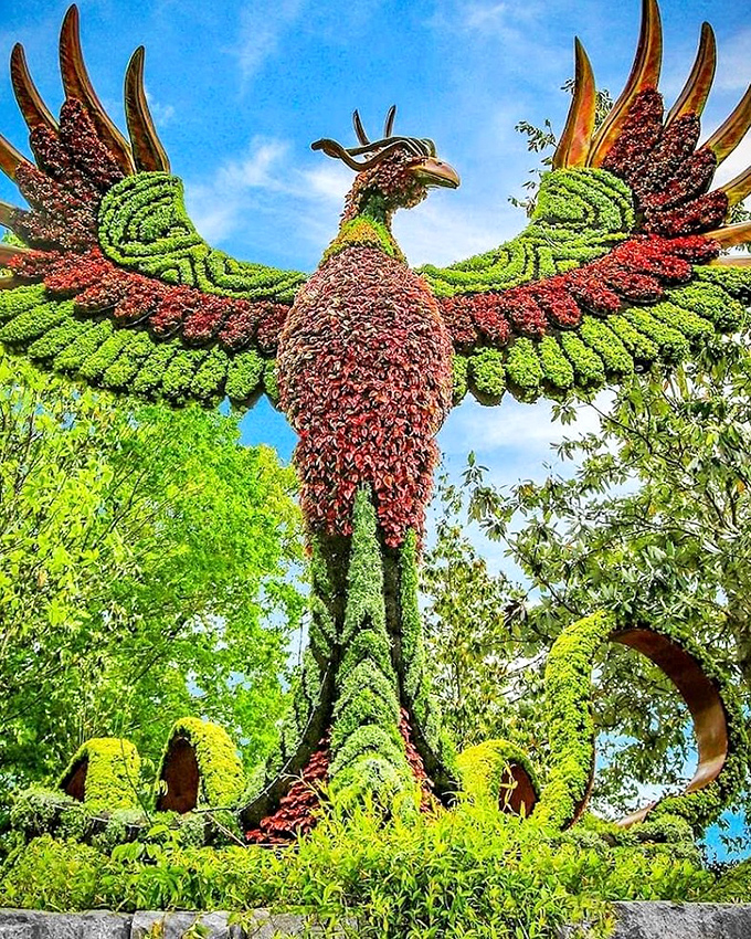 This isn't your average phoenix&mdash;it's a botanical masterpiece rising from beds of flowers instead of ashes, its wings spread in vibrant botanical plumage.