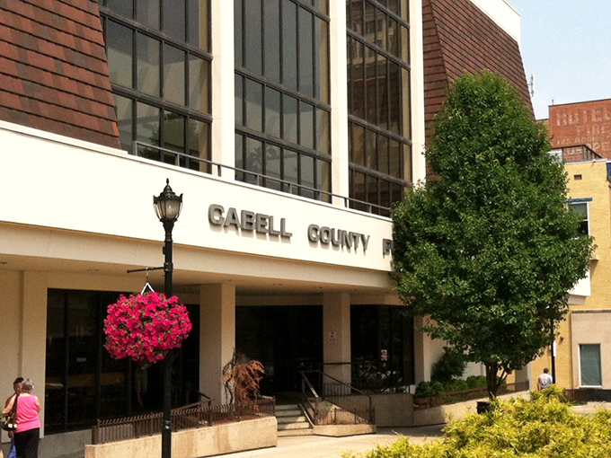 The Cabell County Public Library blooms with vibrant hanging baskets, proving that even serious repositories of knowledge know how to dress for summer.