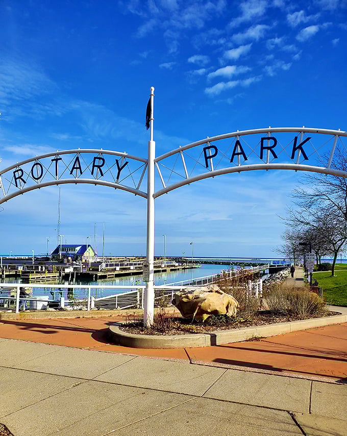 Rotary Park's welcoming arch frames the marina perfectly, promising lazy afternoons watching sailboats dance across Lake Michigan's vast blue stage.