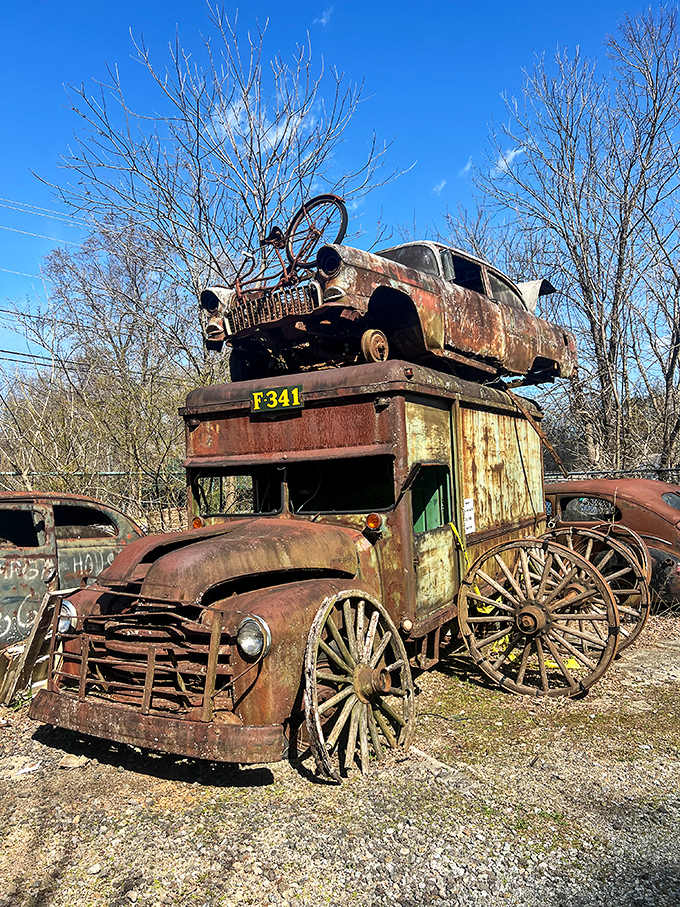Automotive Jenga at its finest. This precarious stack of vintage vehicles defies both gravity and time, creating a rusty roadside totem pole.