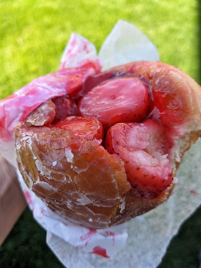 Behold the holy grail of donuts: fresh strawberries bursting from a perfectly glazed vessel. This isn't just breakfast&mdash;it's a California dream wrapped in paper.