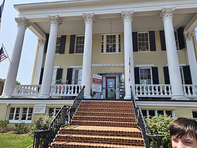 Classical columns frame the view, creating a delightful architectural contrast with the whimsical apple sculpture nearby.