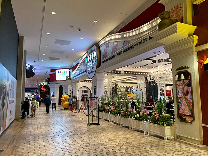 The Sugar Factory storefront dazzles with theatrical lighting and floral displays, tempting even the most disciplined shoppers to indulge their sweet tooth.