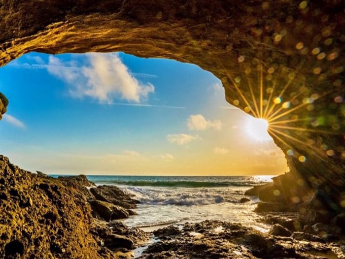 Nature's perfect frame! Sunlight streams through a sea cave opening, creating the kind of moment photographers wait lifetimes to capture.