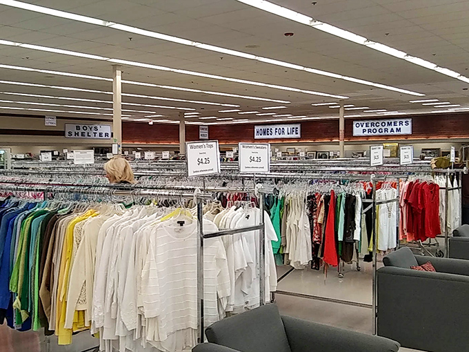 Racks upon racks of neatly organized clothing stretch toward the horizon, with signs highlighting the store's mission-driven programs.