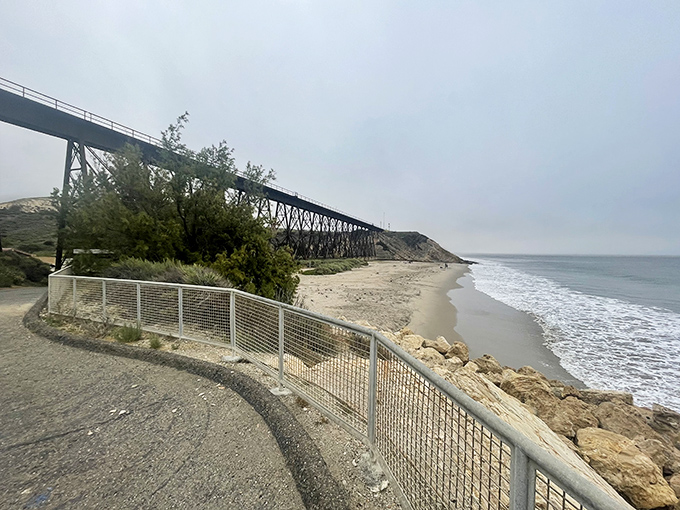 The iconic railroad trestle frames the beach like a postcard from California's golden age, when engineering marvels and natural beauty first learned to coexist.