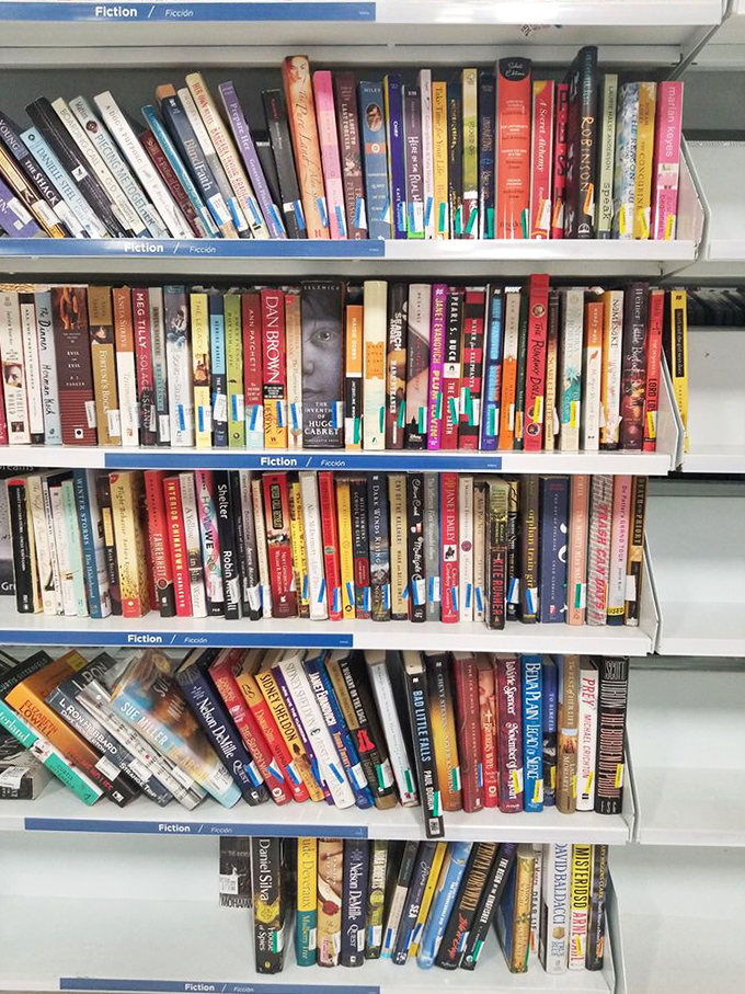 Fiction shelves stocked with stories waiting to transport you somewhere magical without requiring a plane ticket or passport.