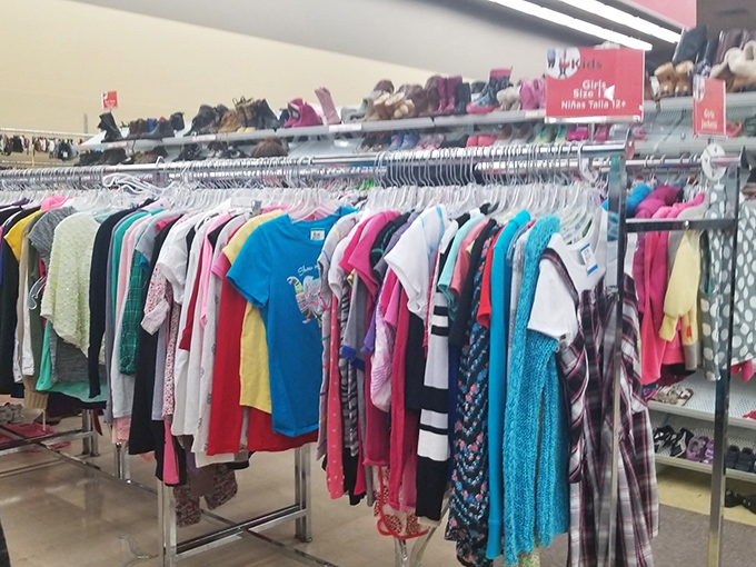 A rainbow of possibilities hangs in perfect formation. Each tiny garment represents both outgrown memories and future adventures waiting to be had.