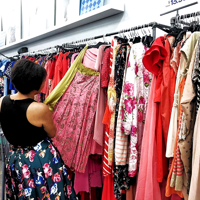 The clothing racks offer a rainbow of possibilities. That pink floral dress might have graced a Manhattan gala before landing here, waiting for its second act.