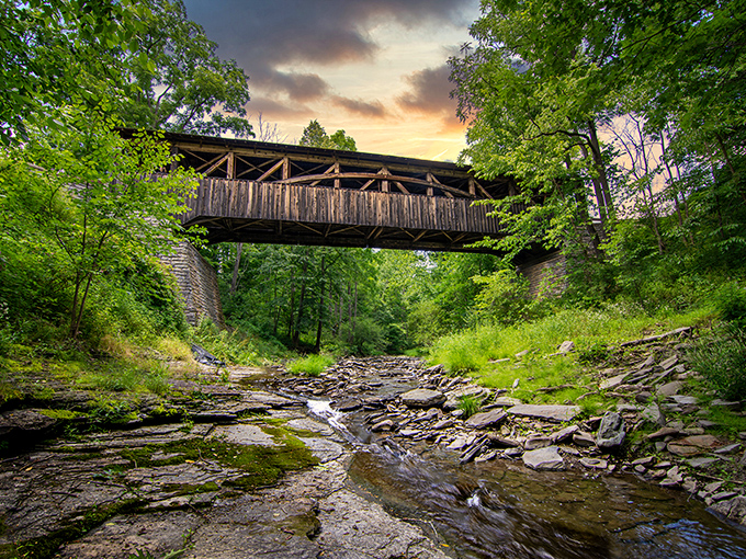 Nature frames its masterpiece at sunset, with Browns Creek flowing beneath this architectural treasure. The bridge seems to float between worlds.