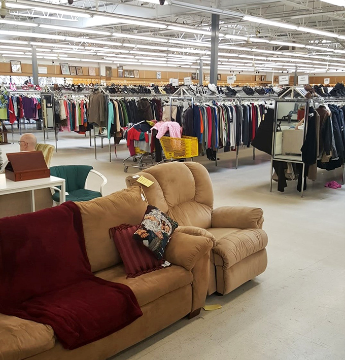 Rows of clothing stretch endlessly under bright warehouse lighting, making this look more boutique than basement sale.