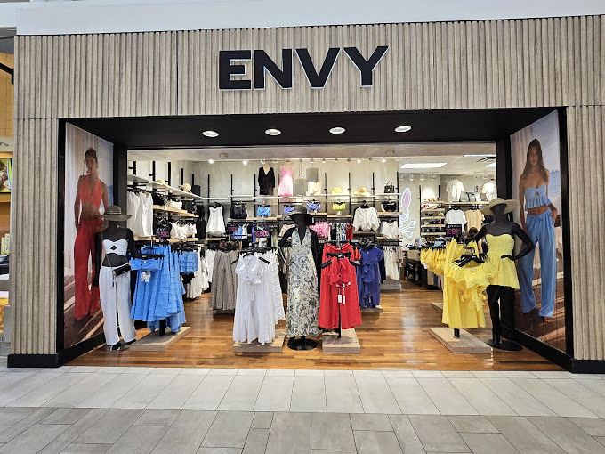 Envy's colorful display window showcases the season's trends, tempting passersby with a rainbow of fashion possibilities that whisper, "Your closet needs this."