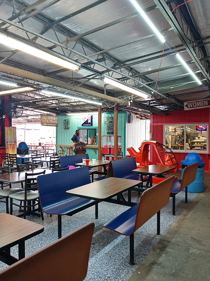 The food court's vibrant turquoise and red walls match the lively atmosphere. Blue chairs invite weary shoppers to rest while plotting their next treasure hunt.