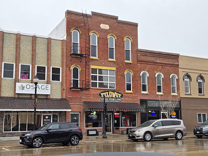 The Tap Top Bar beckons with neon promise on a rainy day. In Osage, even the puddles reflect small-town hospitality.