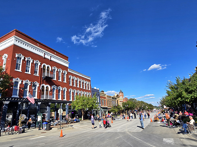 Main Street stretches toward the horizon like a scene from a nostalgic film, where red brick buildings frame a perfect small-town tableau.