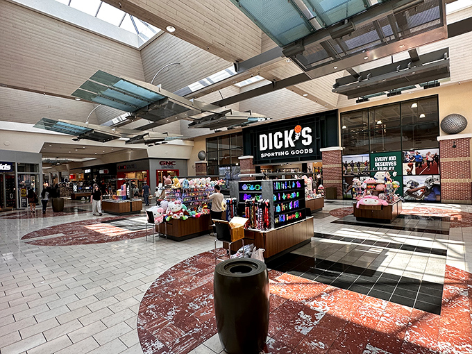 Gleaming floors and soaring ceilings create retail runways where shoppers parade with their treasures, bathed in natural light from above.
