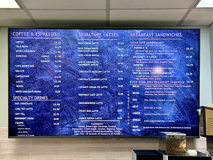 The cosmic blue menu board reads like poetry for the hungry. Each specialty latte promises a liquid dessert experience worth every sip.
