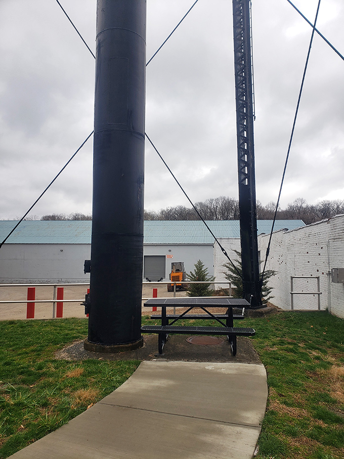 A humble picnic table sits beneath the mighty bottle, perfect for contemplating life's big questions, like "Why isn't all architecture this deliciously literal?"