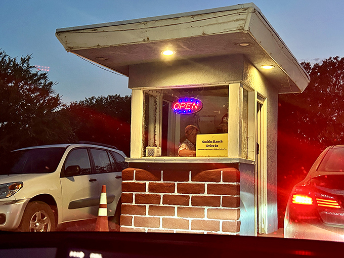This humble ticket booth has welcomed generations of moviegoers, its neon "OPEN" sign a beacon in the desert night.