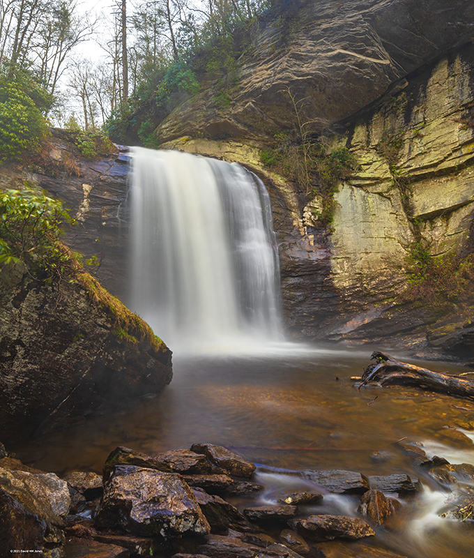 The waterfall's silky white veil contrasts dramatically with the golden-hued rocks, creating what photographers call "the money shot" &ndash; no filter required! 