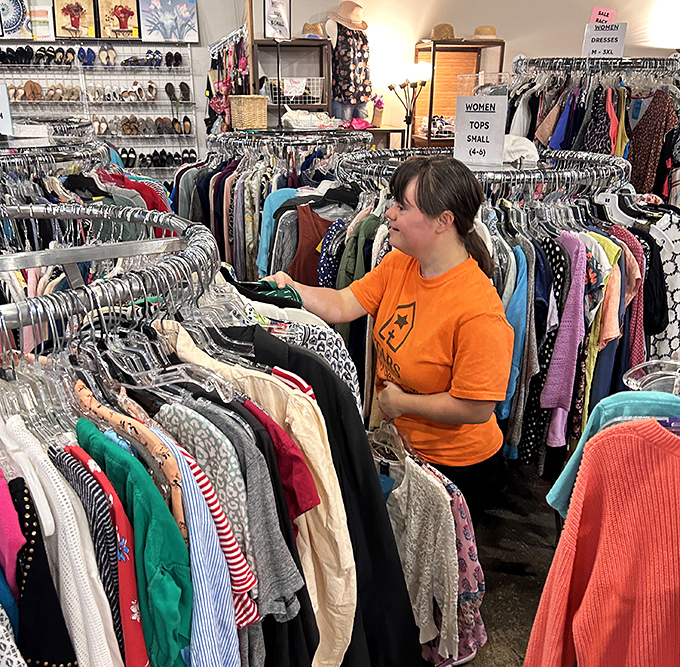 A volunteer navigates the meticulously organized clothing forest&mdash;where fashion finds from yesterday wait for tomorrow's closets.