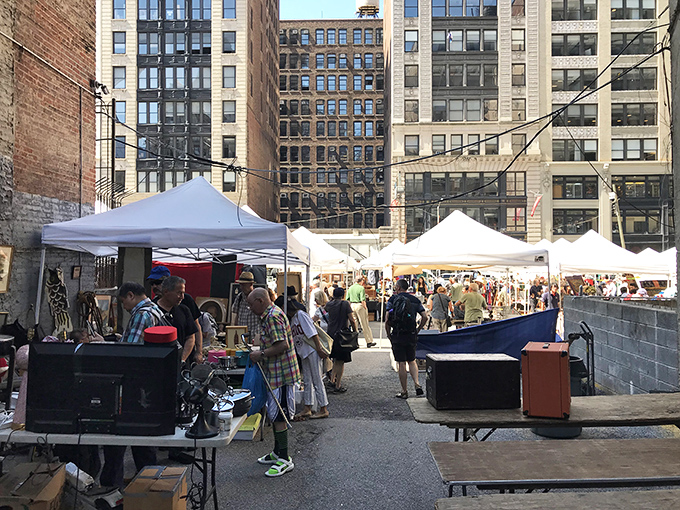 Framed artwork leans against city scaffolding, creating an impromptu gallery that rivals any museum.
