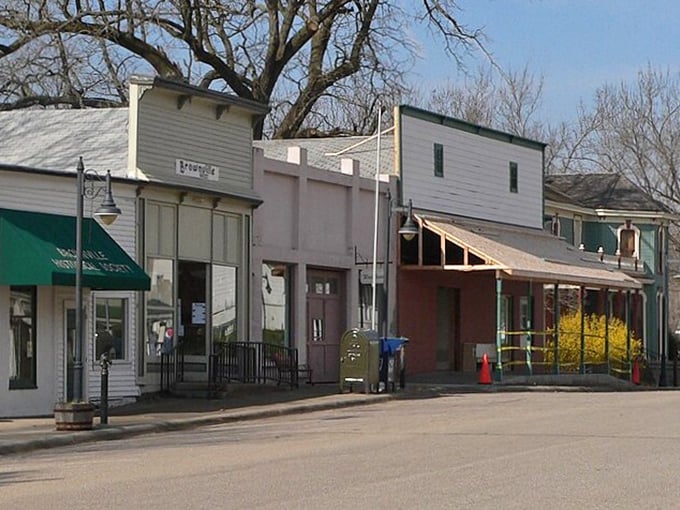 Historic storefronts with green awnings and bare winter trees create a timeless small-town scene.