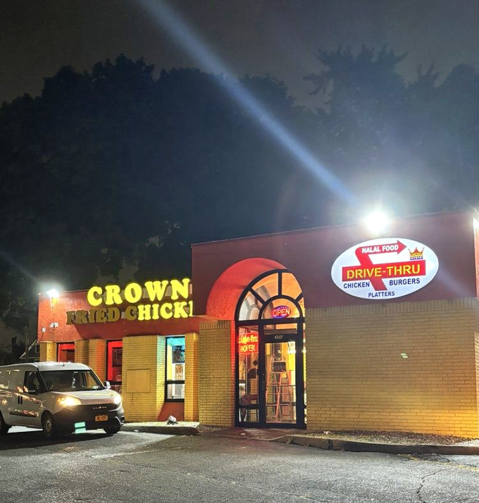 Crown Fried Chicken's vibrant yellow building glows like a midnight beacon for hungry night owls seeking crispy satisfaction.