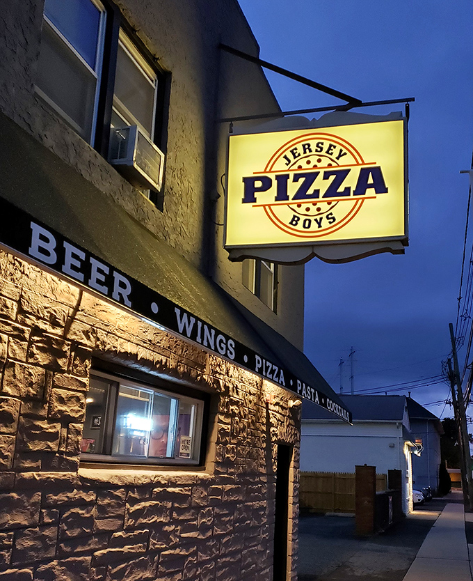 Jersey Pizza Boys' illuminated storefront promises late-night pizza salvation. The brick building houses pizza magic that locals have treasured for years.
