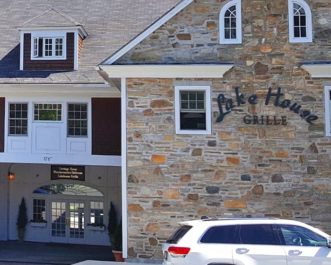 That stone wall and elegant entrance hint at the upscale dining experience waiting inside, where lake views steal the show.