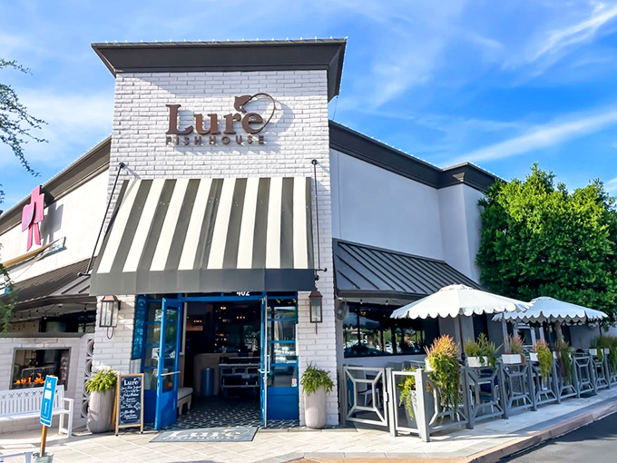 Lure Fish House's elegant white brick exterior and striped awnings set the stage for a sophisticated seafood experience.