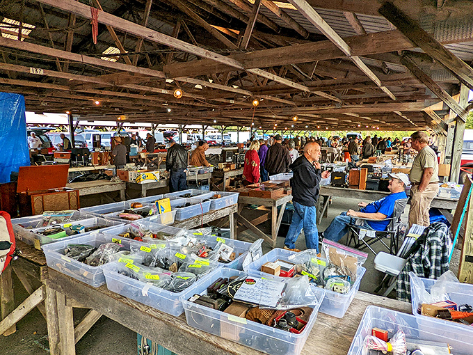 Renninger's treasure trove! Plastic bins overflow with vintage tools and hardware under the rustic wooden pavilion where serious collectors gather.