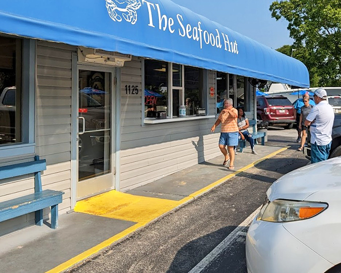 That little blue bench outside The Seafood Hut? It's where patience meets anticipation for seafood worth waiting for.