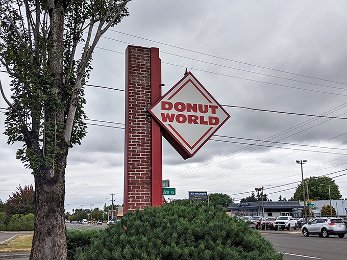 Donut World's bold red sign promises simple pleasures done right. No frills, just perfectly executed donut craftsmanship waiting inside.