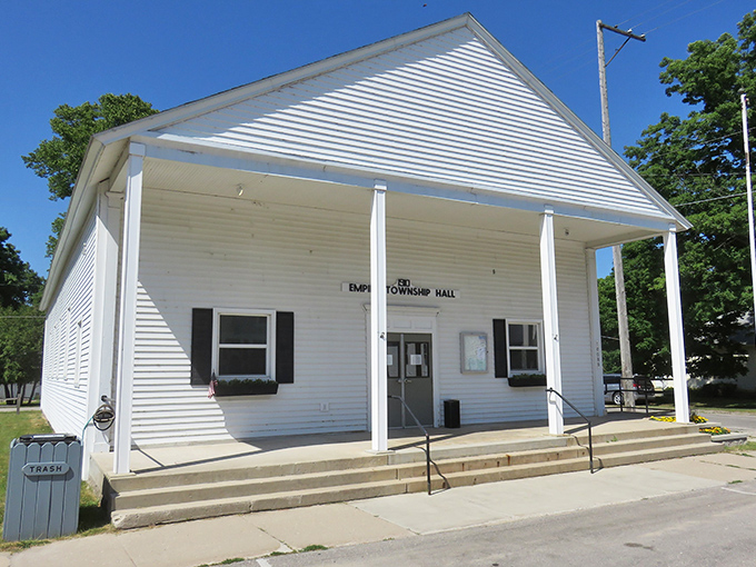 Classic white township hall stands proudly as Empire's community heartbeat, where local history unfolds one meeting at a time.