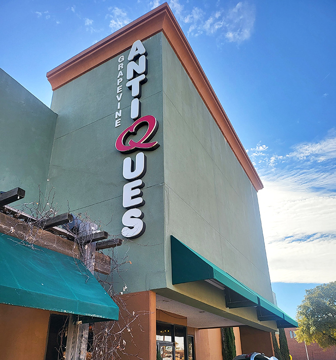 The towering sign promises antique adventures inside &ndash; like a lighthouse for treasure hunters in a sea of modernity.