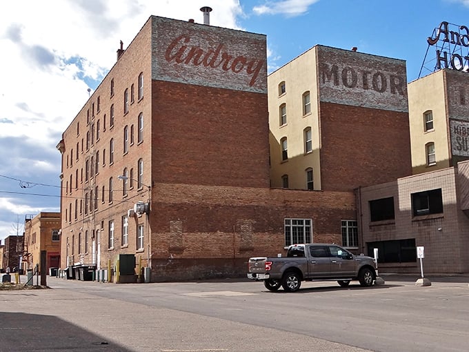 Faded ghost signs whisper stories of Hibbing's past, where the Androy Hotel's weathered brick walls have seen it all.
