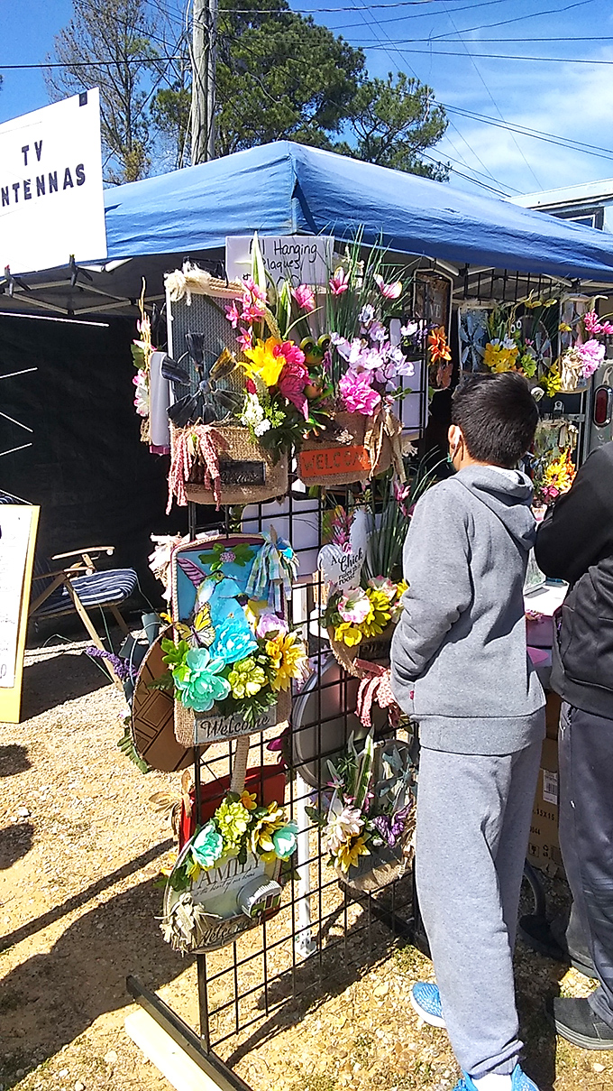 Colorful hanging baskets at Mississippi Flea Market add charm while shoppers browse for their next discovery.