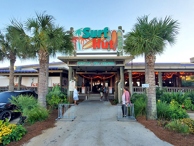 Palm trees stand guard at Surf Hut's entrance, where Destin's emerald waters and fresh seafood await just beyond the door.