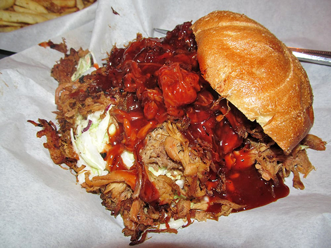 This isn't just a sandwich; it's a gravity-defying monument to pulled pork where napkins aren't optional—they're a survival tool.