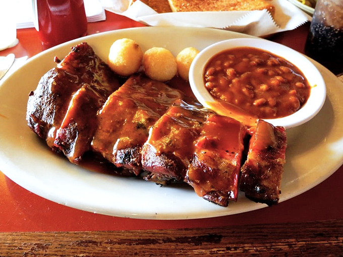 Glistening ribs that don't just fall off the bone—they practically leap into your mouth. Those little potato nuggets? Perfect sauce-sopping companions.