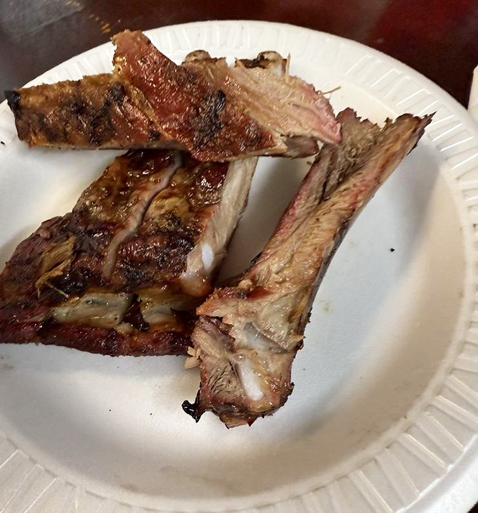 These ribs aren't just cooked, they're transformed - that perfect pink smoke ring beneath the bark tells a story of patience and expertise.